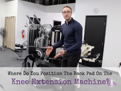 Where do you position the back pad on the knee extension machine?